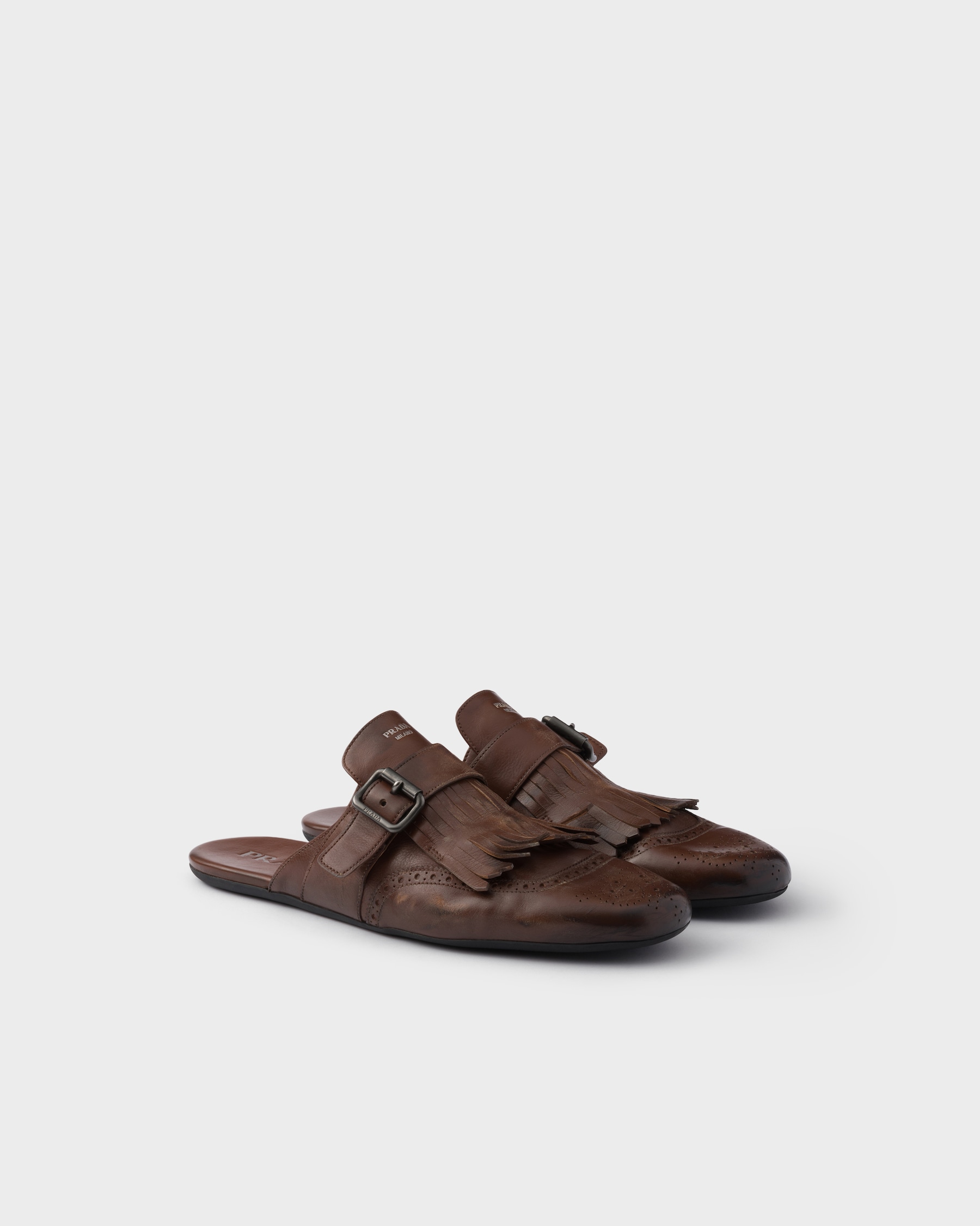 Cognac Shuffle Antiqued Leather Mules With Buckled Strap And Fringe | PRADA